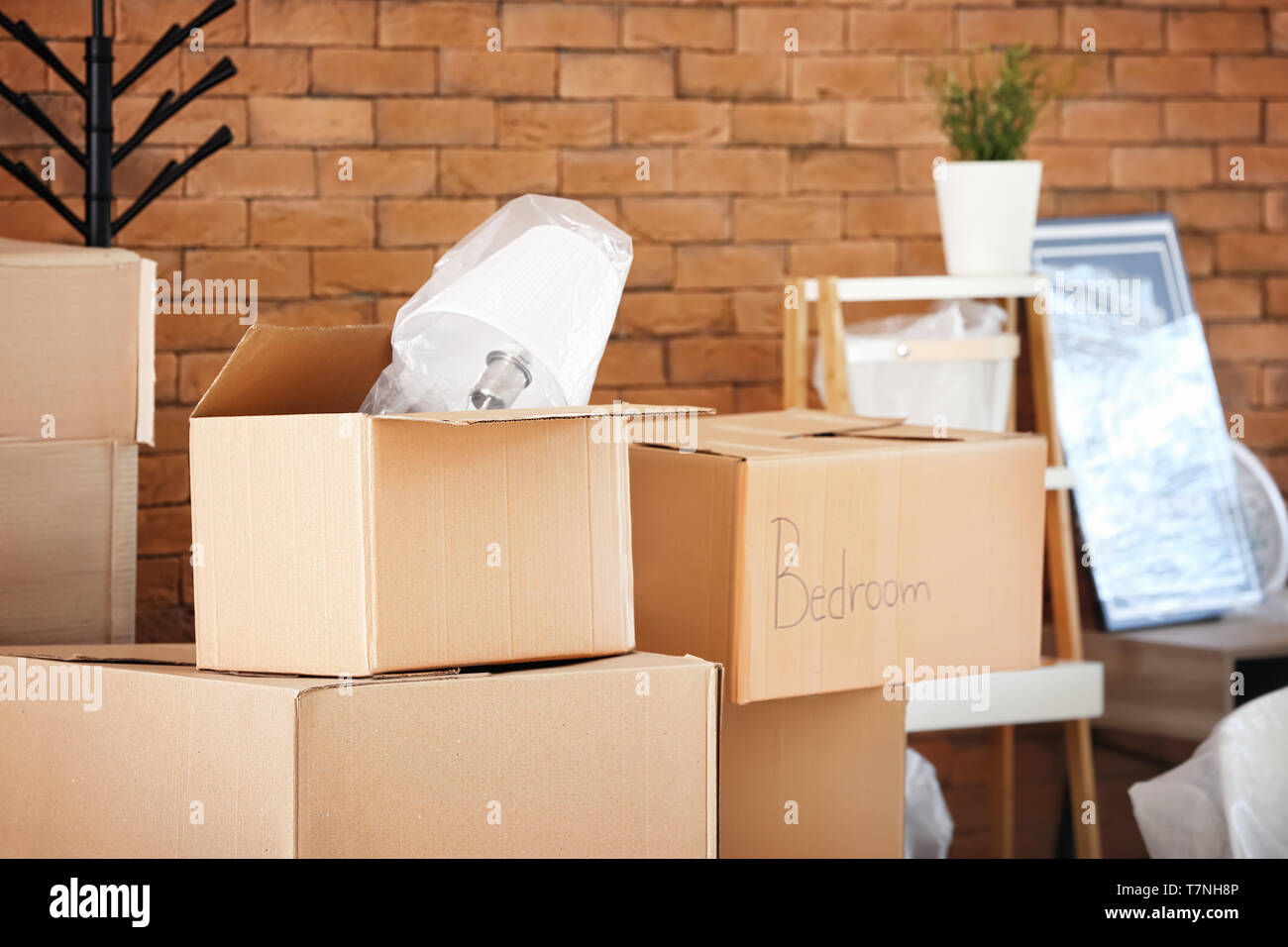Carton boxes and interior items in room. Moving house concept Stock ...