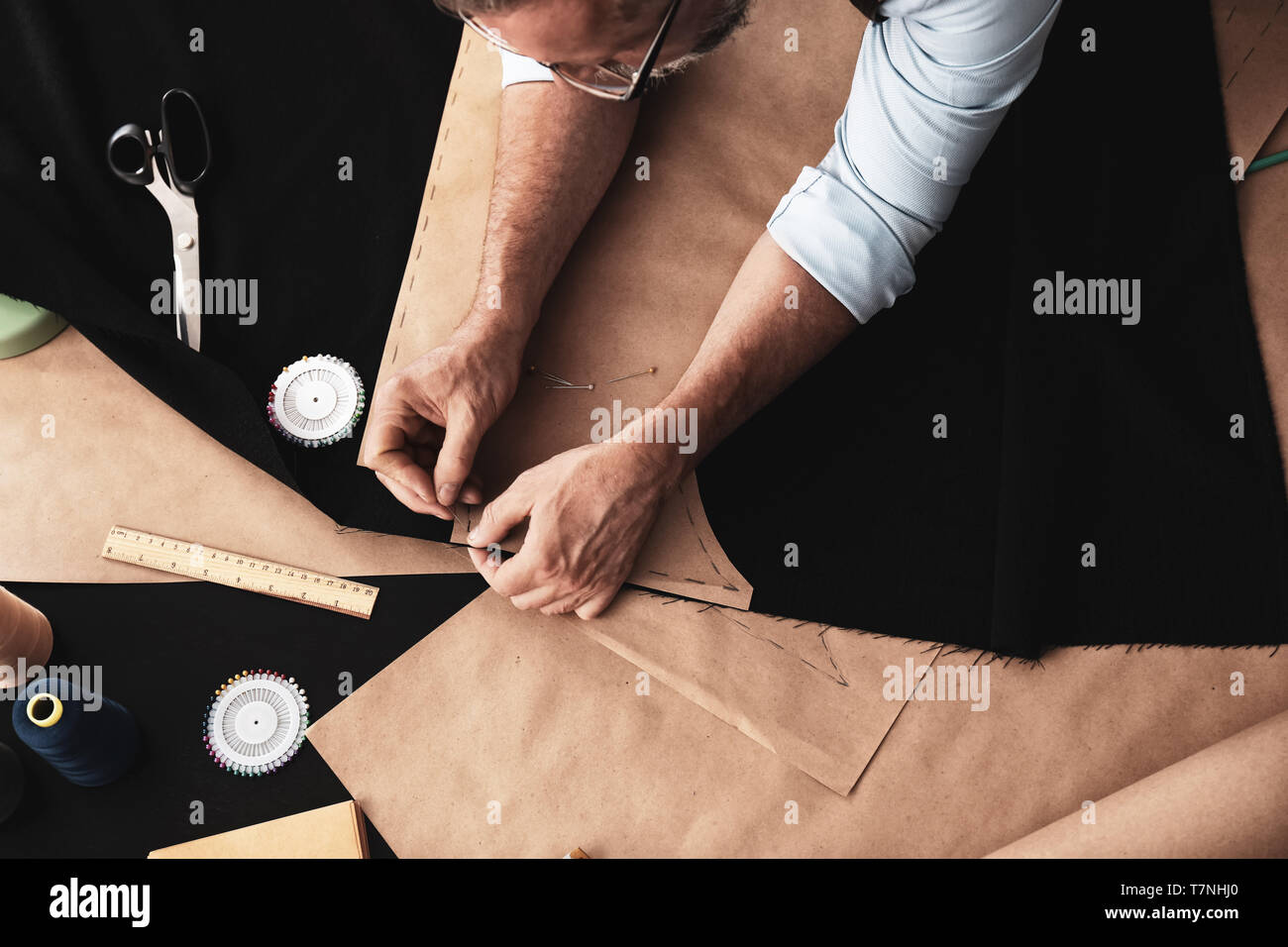 Mature tailor working with sewing pattern in atelier Stock Photo - Alamy