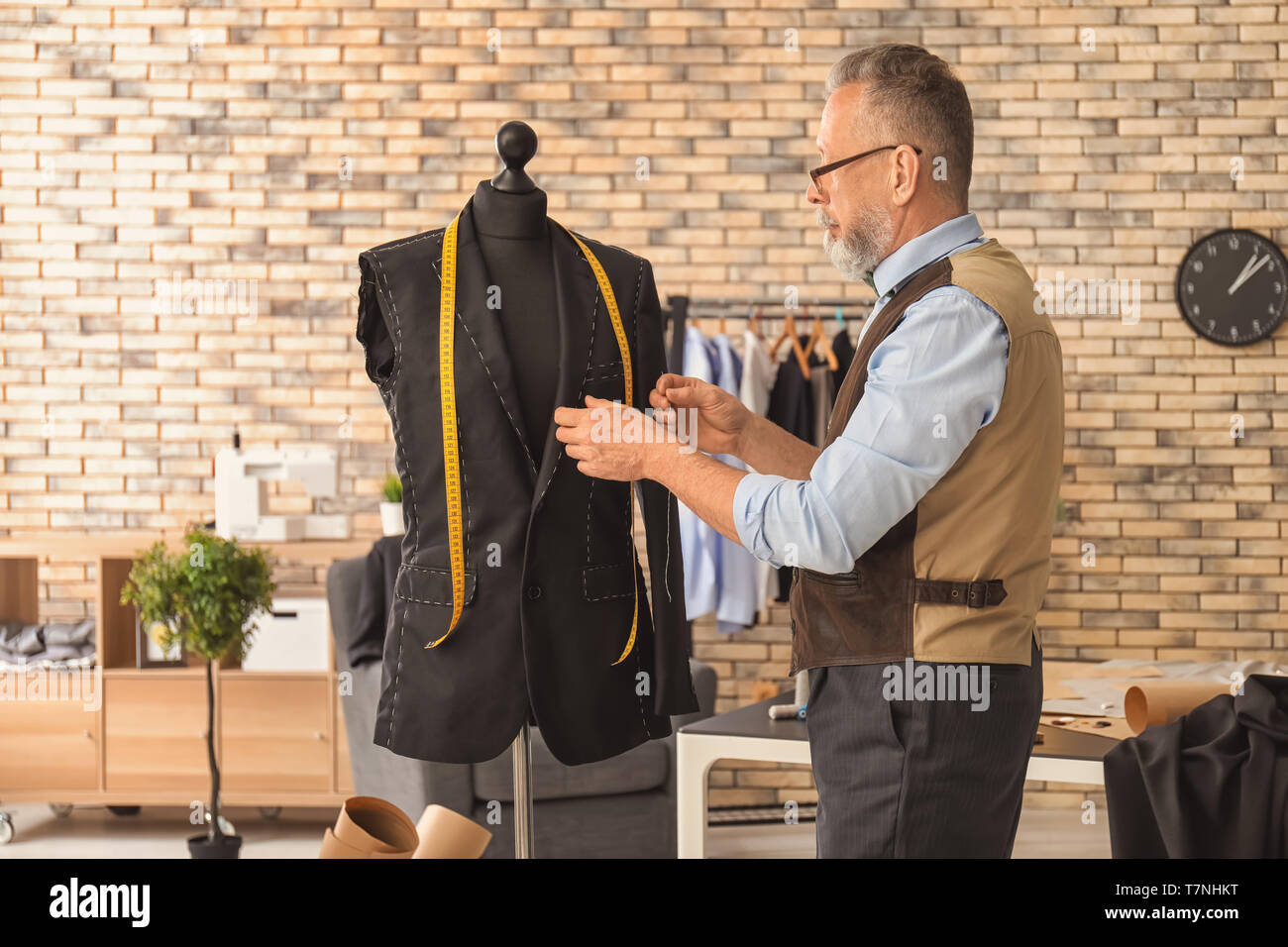 Seamster tailoring jacket on mannequin in atelier Stock Photo - Alamy