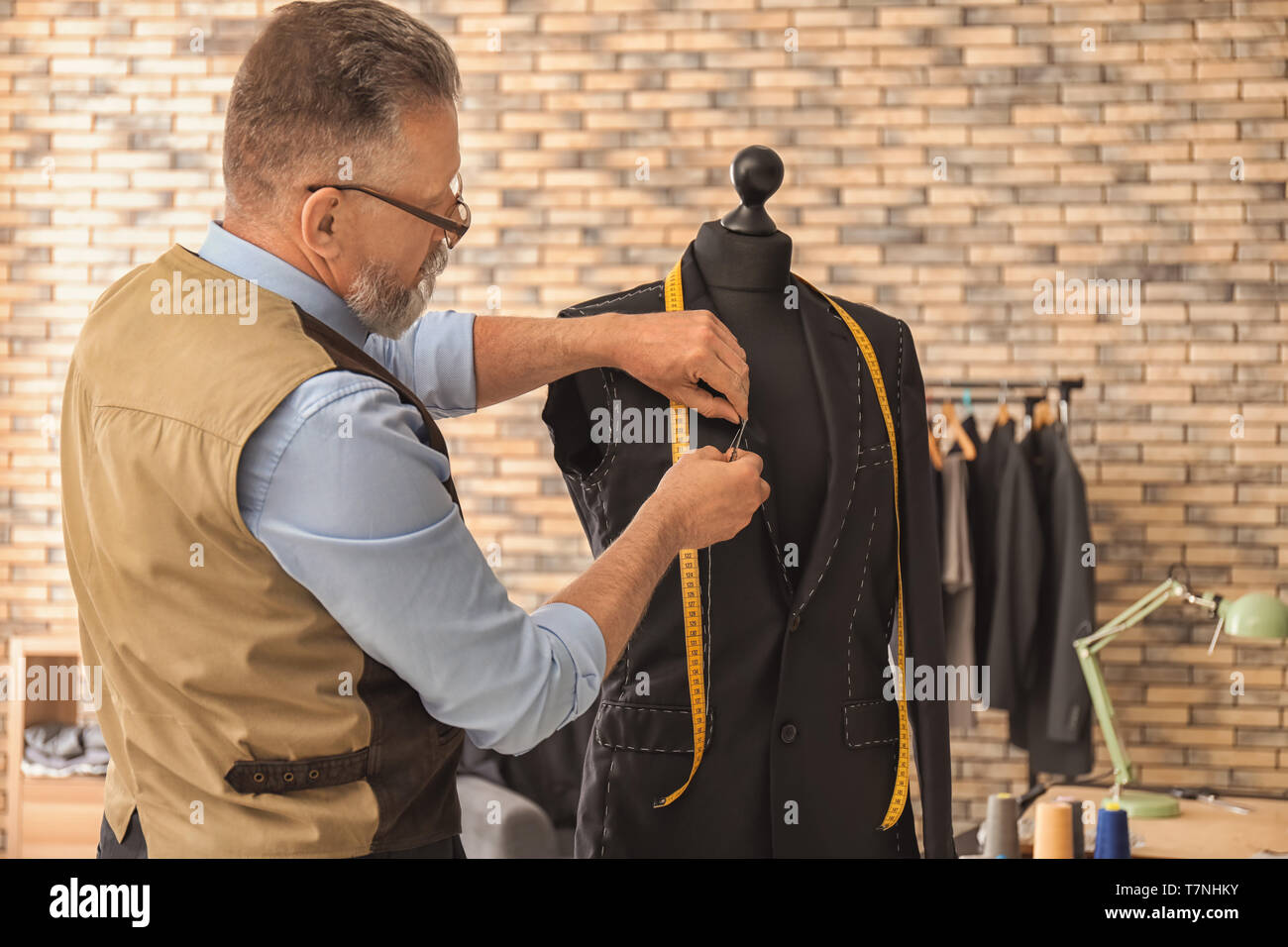 Seamster tailoring jacket on mannequin in atelier Stock Photo - Alamy