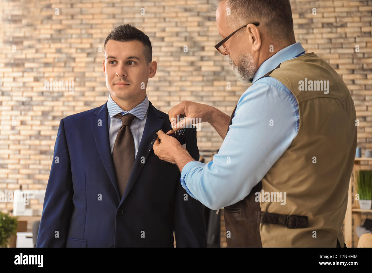 Seamster tailoring suit for client in atelier Stock Photo - Alamy