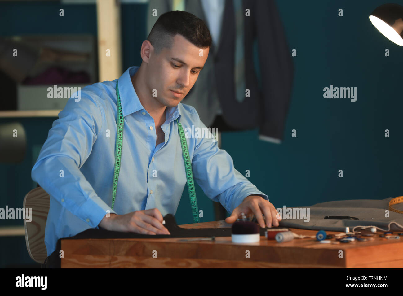 Young tailor marking fabric with chalk in atelier Stock Photo - Alamy