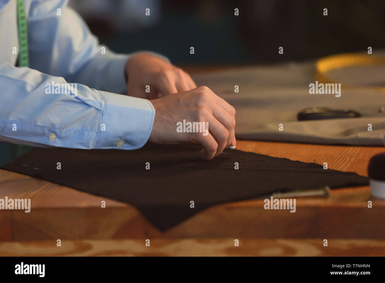 Young tailor marking fabric with chalk in atelier Stock Photo - Alamy