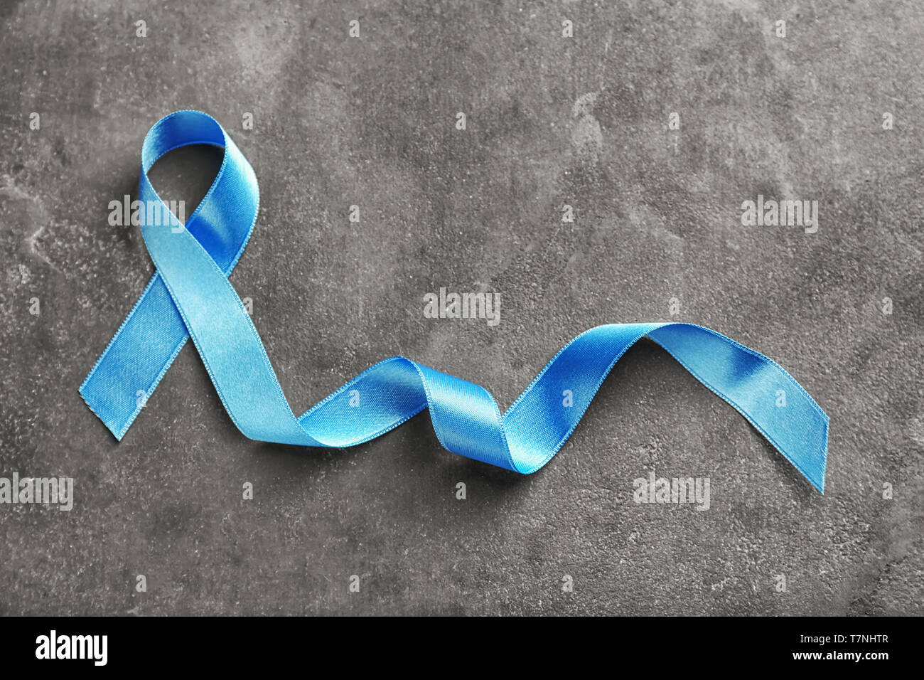 Blue ribbon on grey background. Prostate cancer concept Stock Photo - Alamy