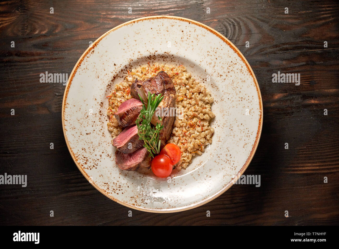 Shredded meat dish with garnish decorated with vegetables on a white ...