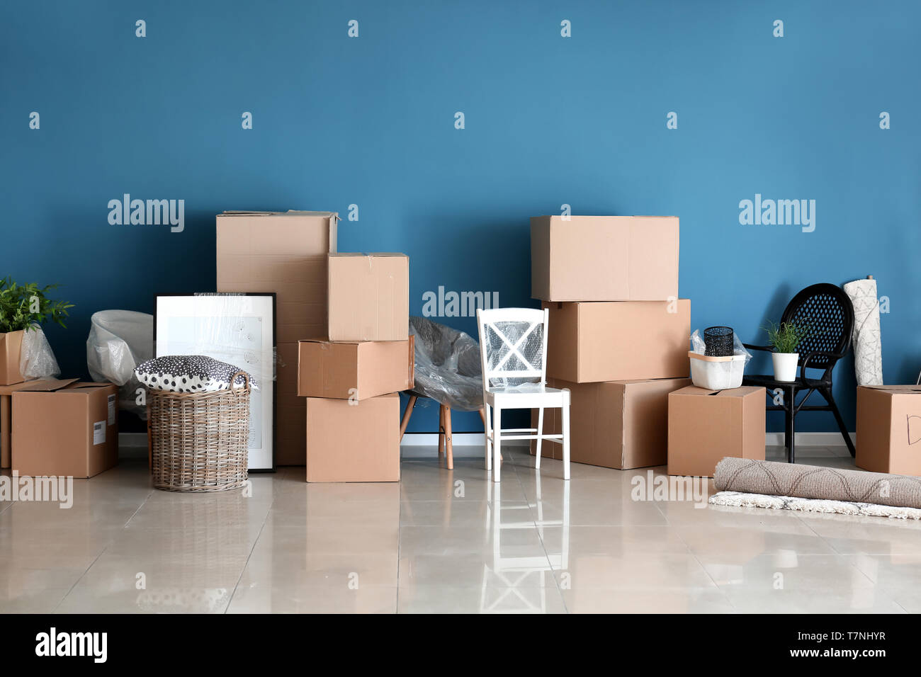 Carton boxes and interior items on floor in room. Moving house concept ...