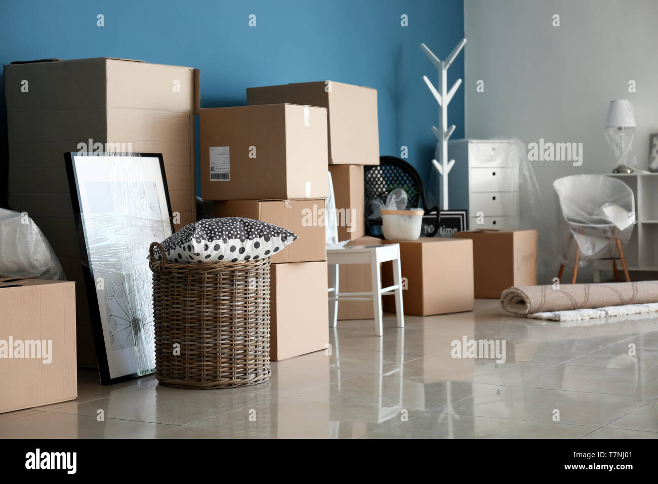 Carton boxes and interior items on floor in room. Moving house concept ...