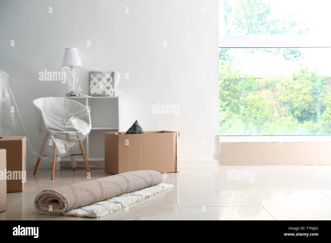Carton boxes and interior items on floor in room. Moving house concept ...