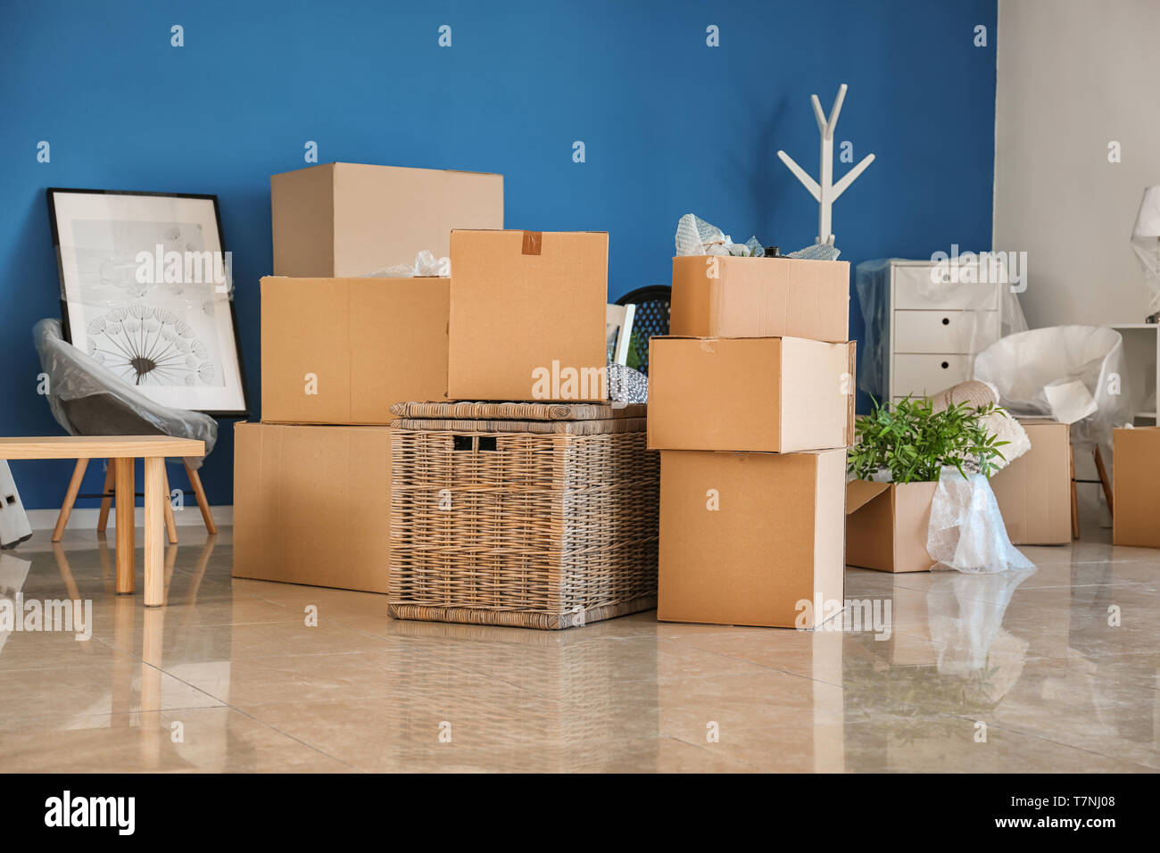 Carton boxes and interior items on floor in room. Moving house concept ...