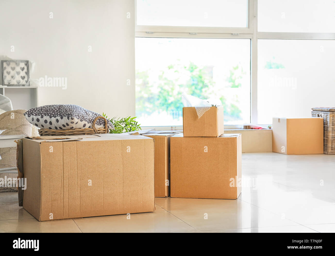 Carton boxes and interior items on floor in room. Moving house concept ...