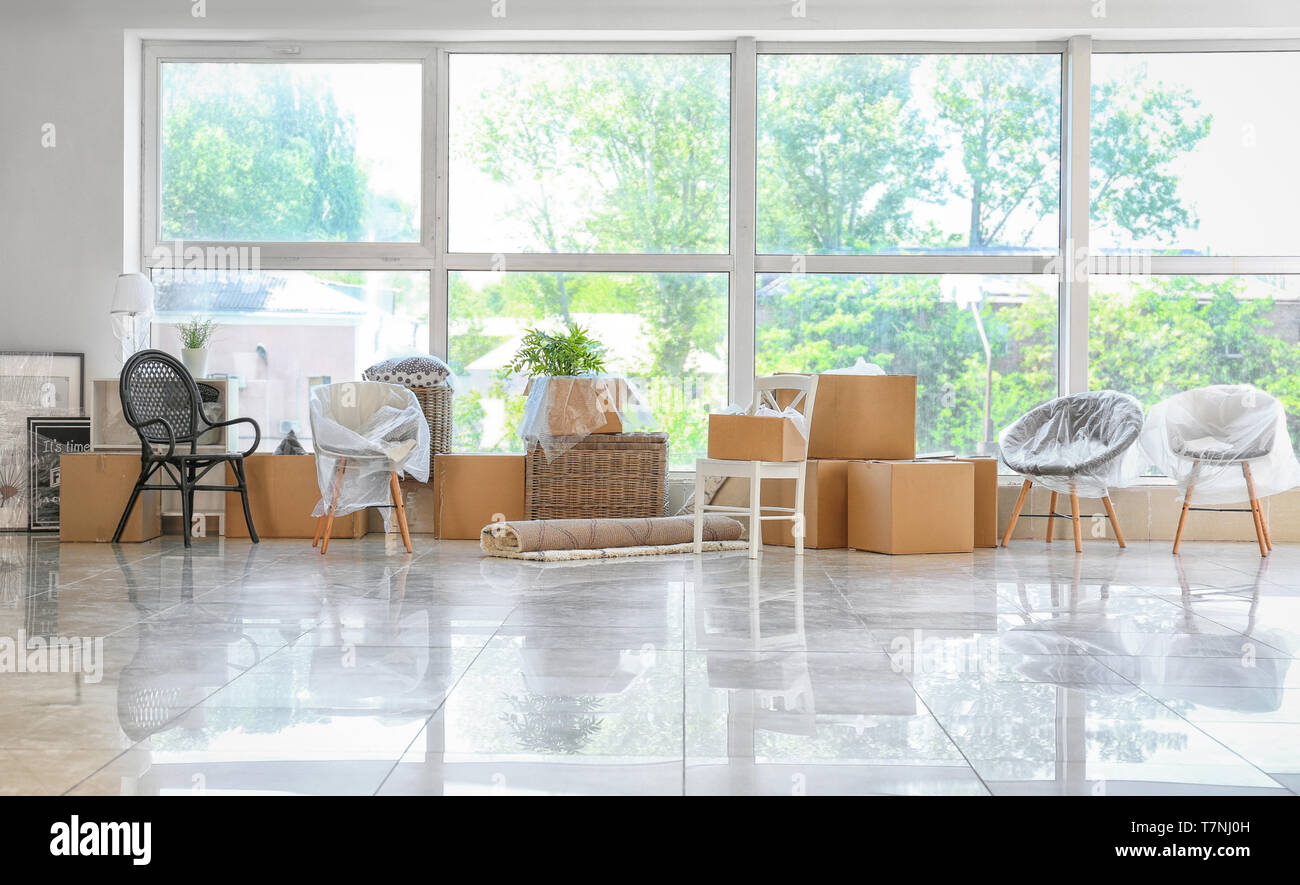 Carton boxes and interior items on floor in room. Moving house concept ...