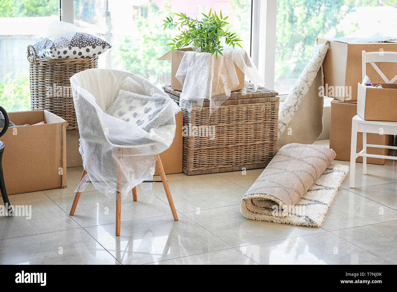 Carton boxes and interior items on floor in room. Moving house concept ...