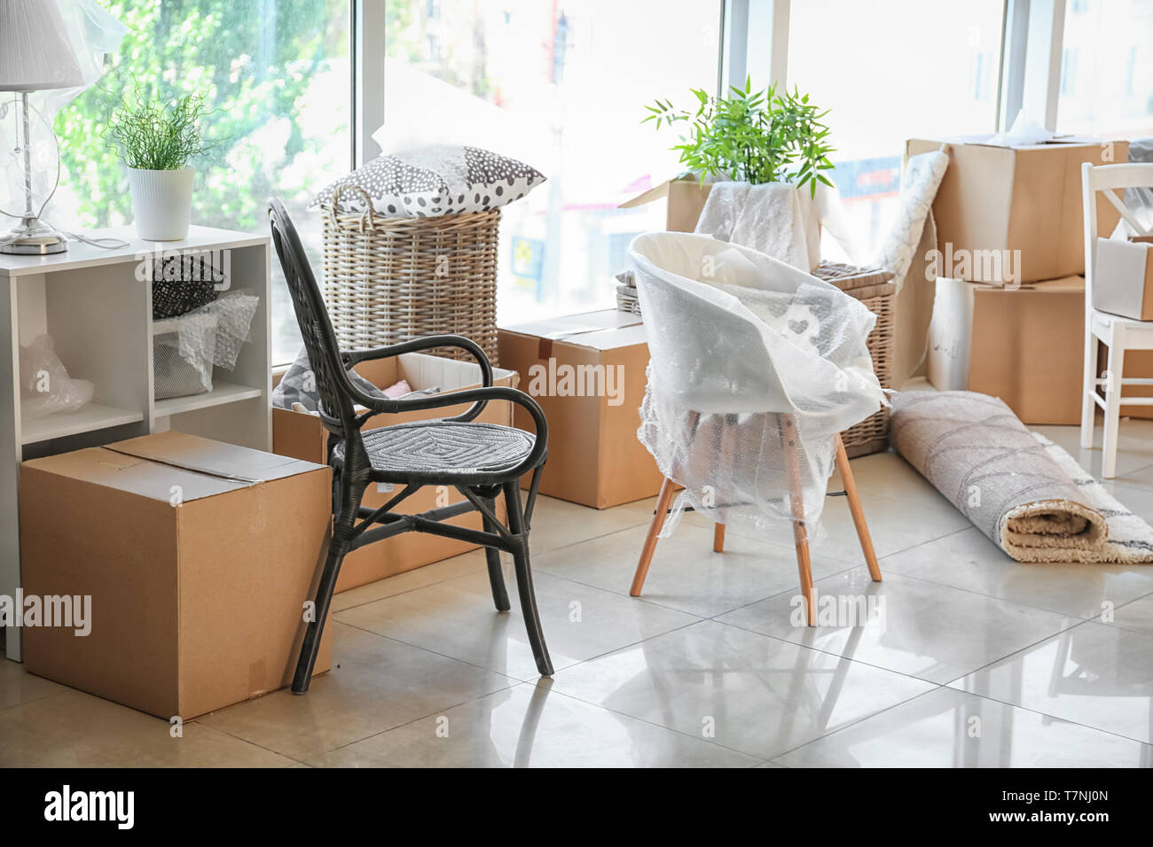 Carton boxes and interior items on floor in room. Moving house concept ...