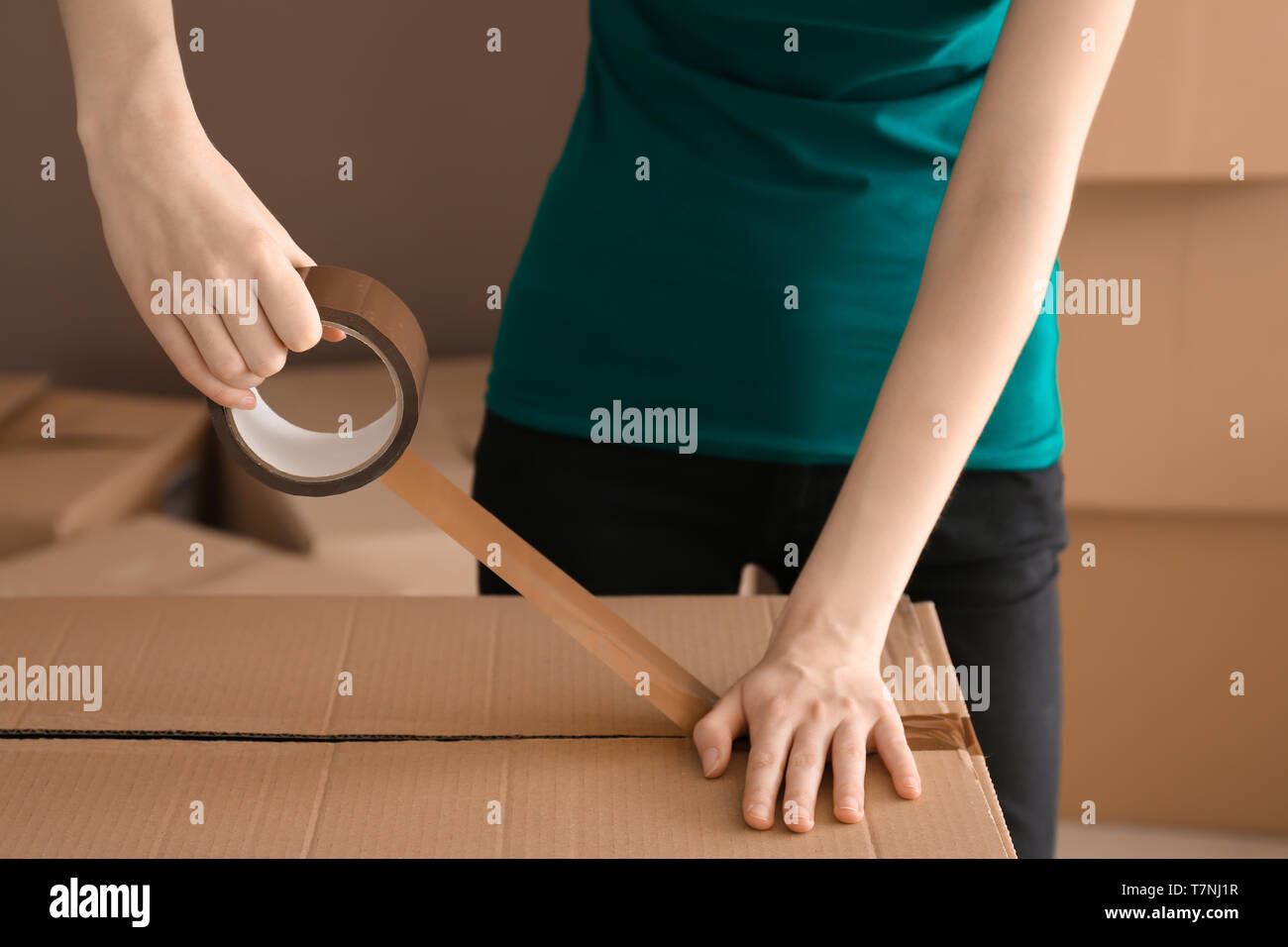 Woman packing carton box indoors. Moving house concept Stock Photo - Alamy