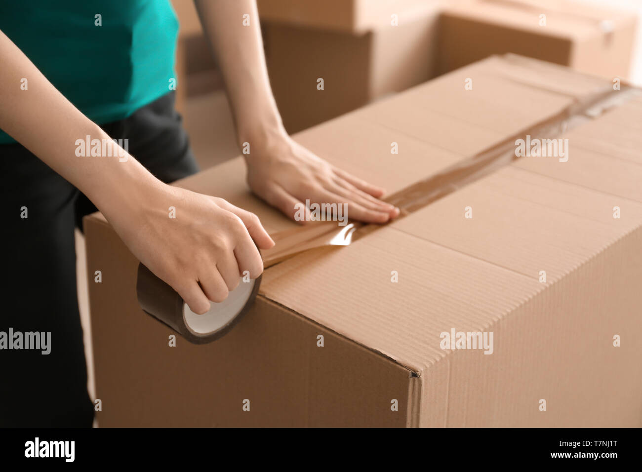 Woman packing carton box indoors. Moving house concept Stock Photo - Alamy