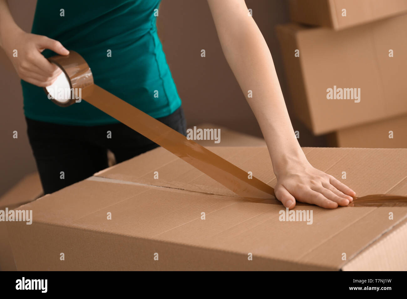 Woman packing carton box indoors. Moving house concept Stock Photo - Alamy