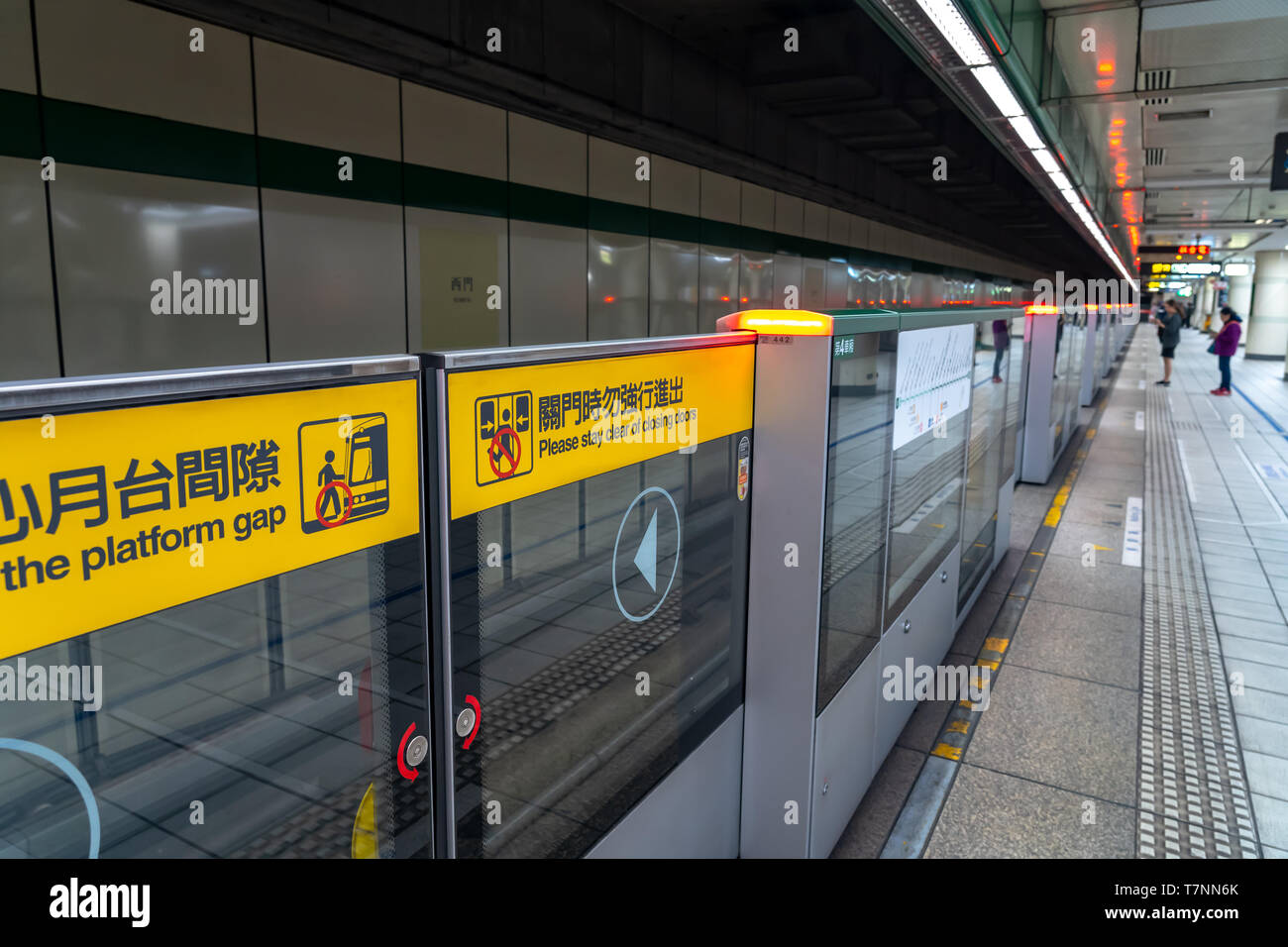 Taipei metro station hall and platform. Subway passengers walk through ...