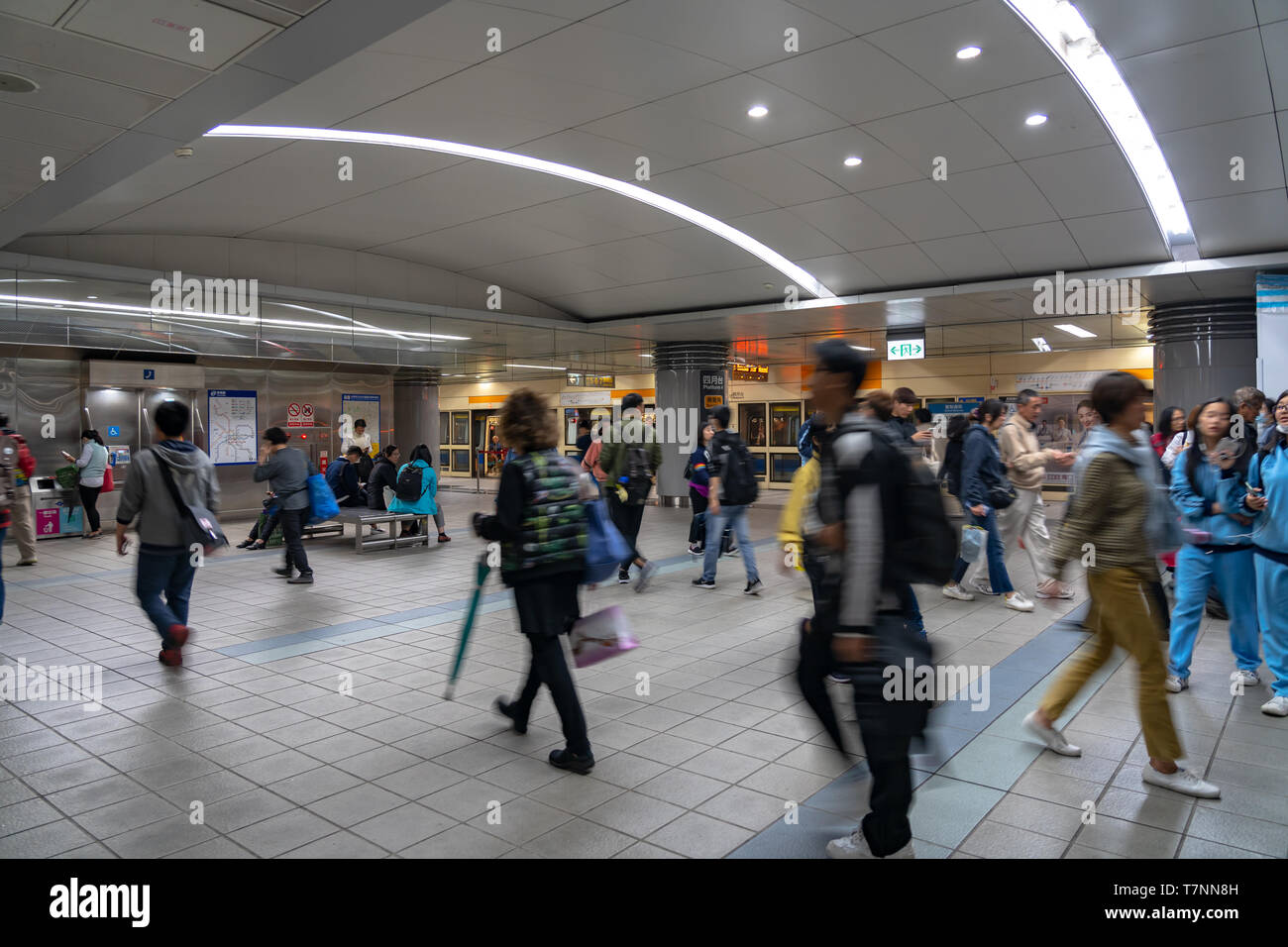 Taipei metro station hall and platform. Subway passengers walk through ...