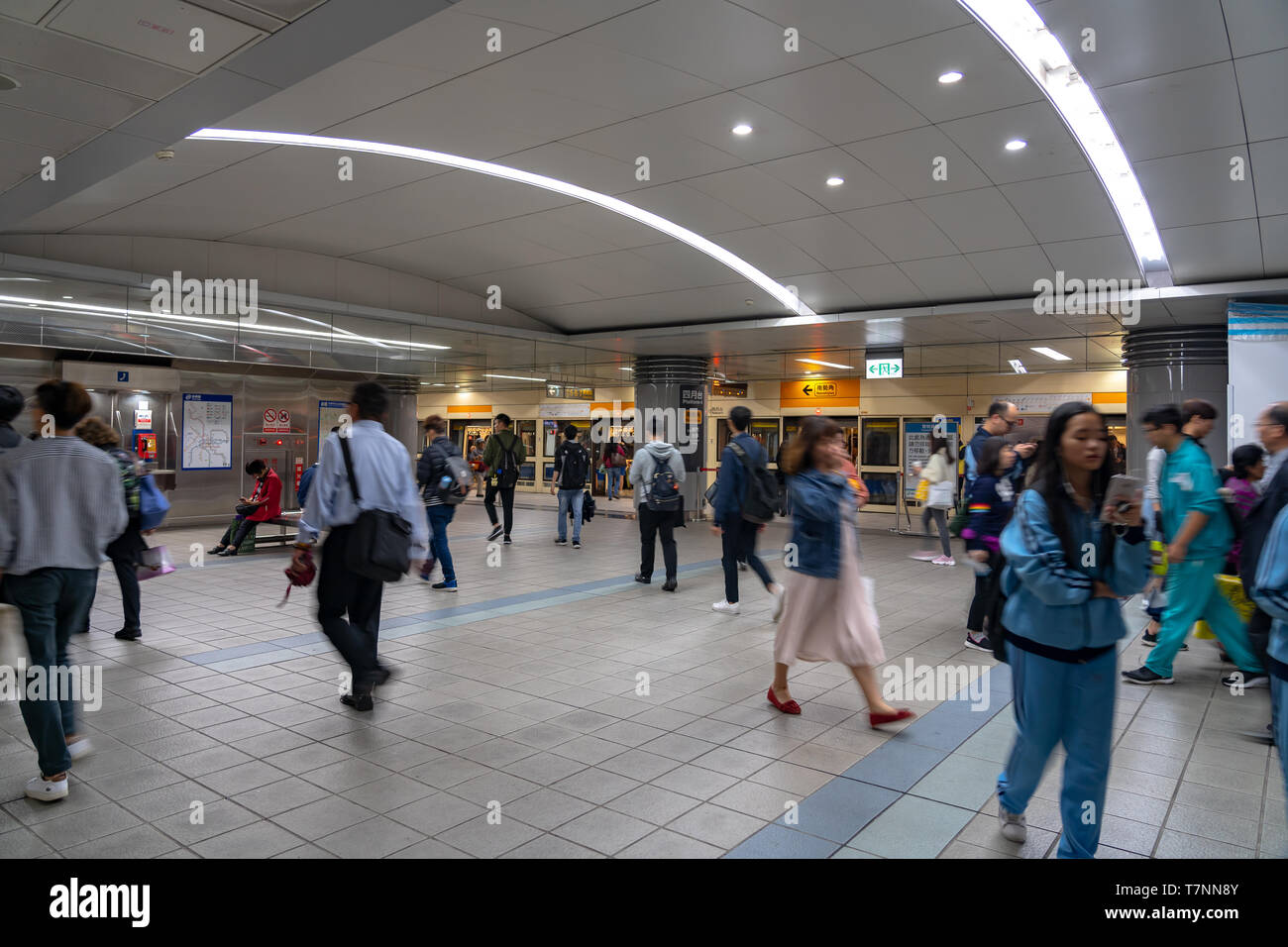 Taipei metro station hall and platform. Subway passengers walk through ...