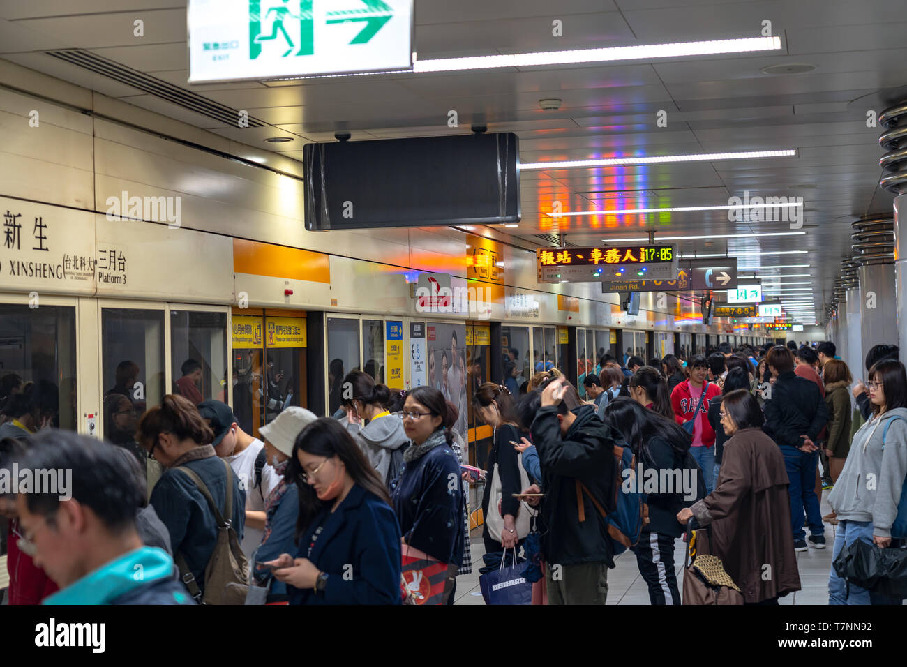 Taipei metro station hall and platform. Subway passengers walk through ...