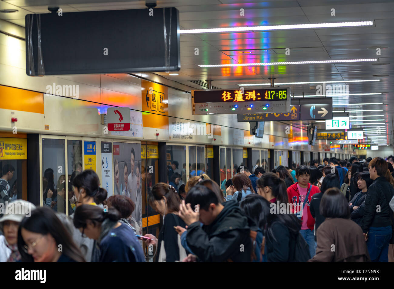 Taipei metro station hall and platform. Subway passengers walk through ...