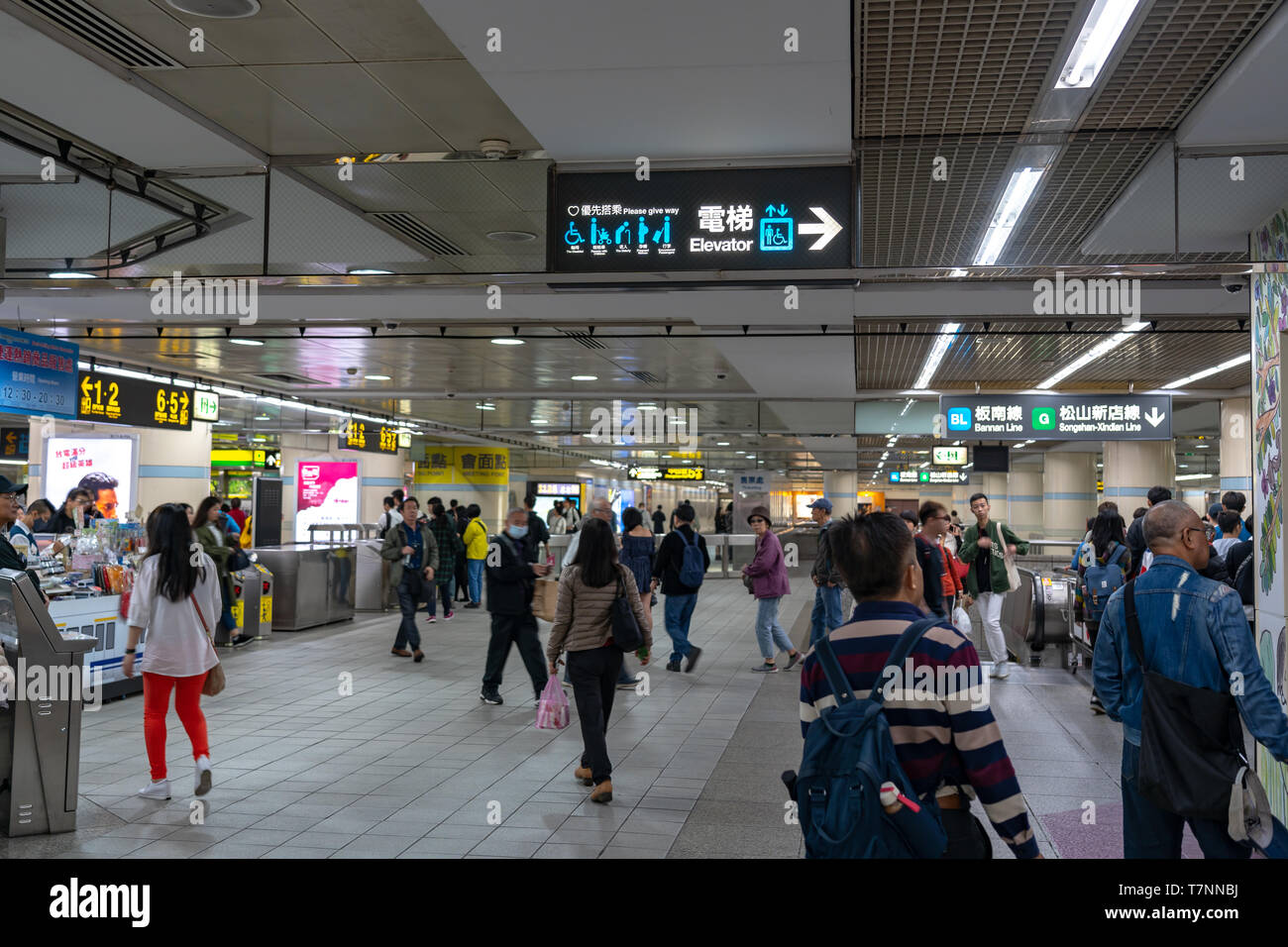 Taipei metro station hall and platform. Subway passengers walk through ...
