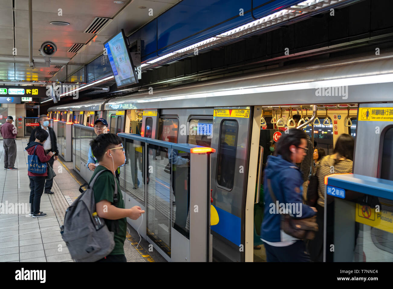 Taipei metro station hall and platform. Subway passengers walk through ...