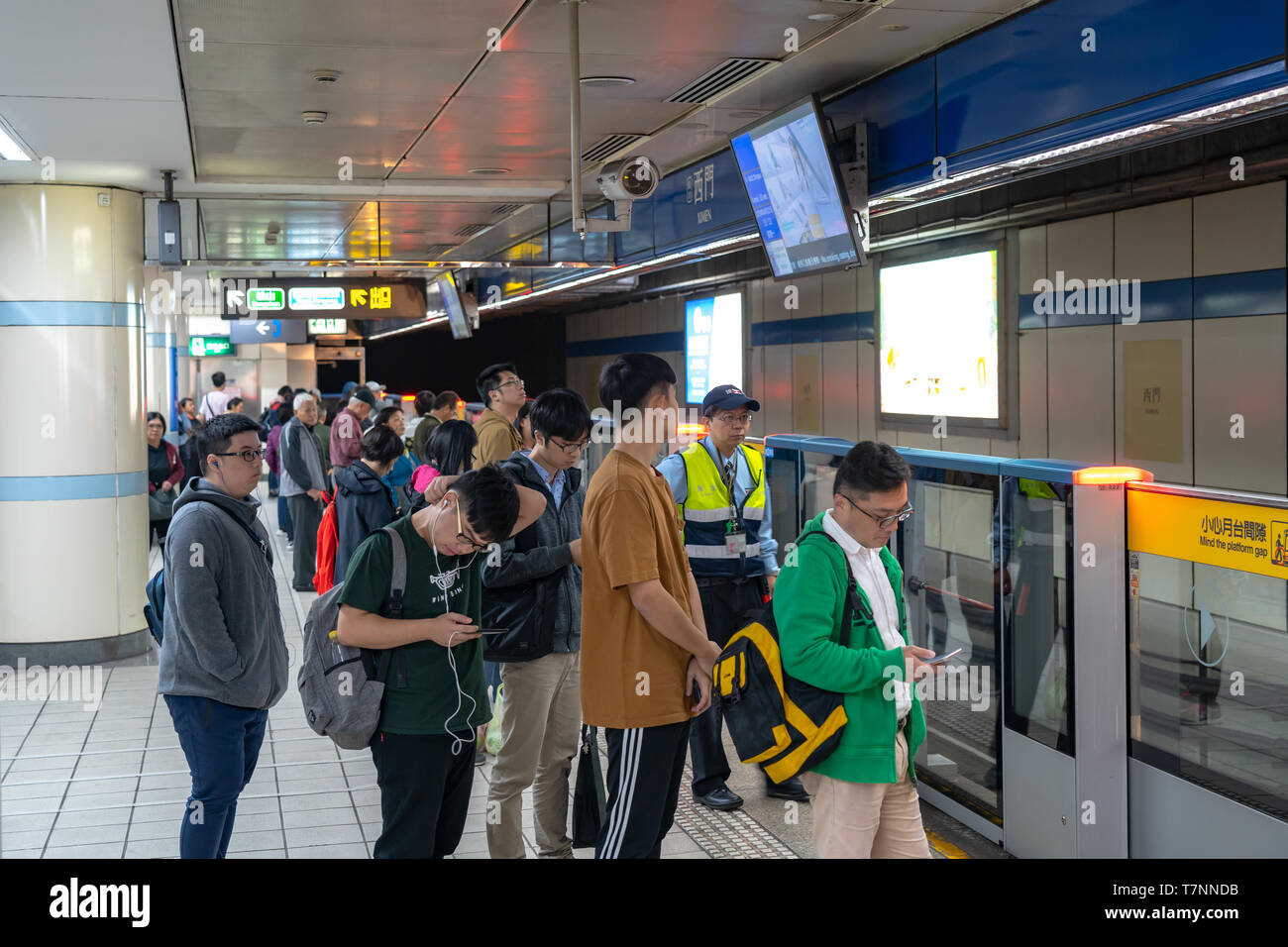 Taipei metro station hall and platform. Subway passengers walk through ...