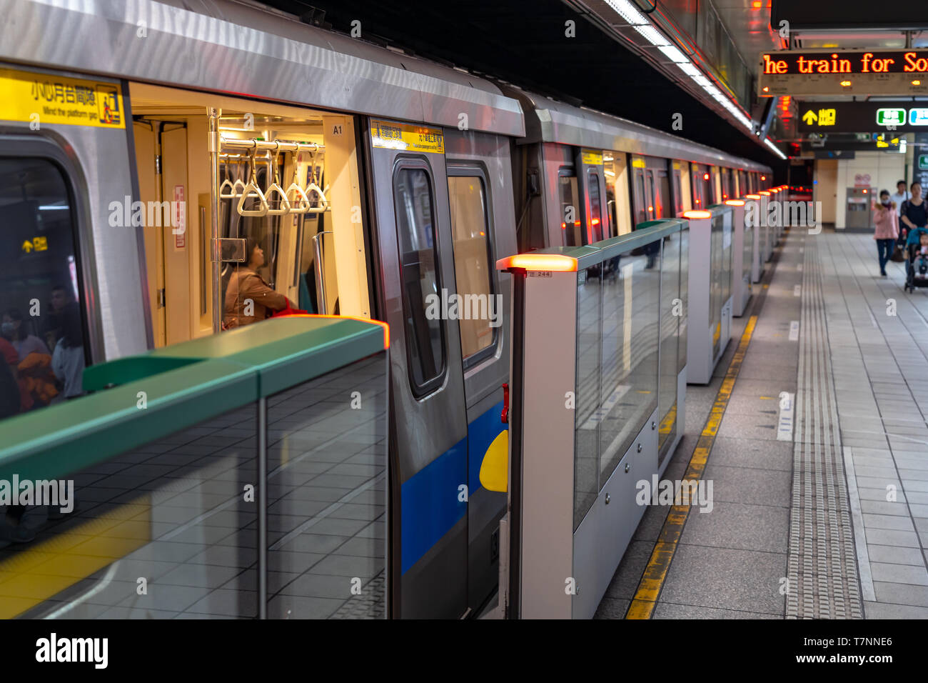 Taipei metro station hall and platform. Subway passengers walk through ...