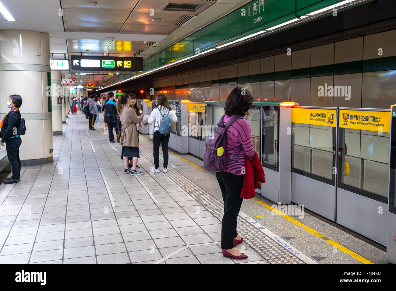 Taipei metro station hall and platform. Subway passengers walk through ...