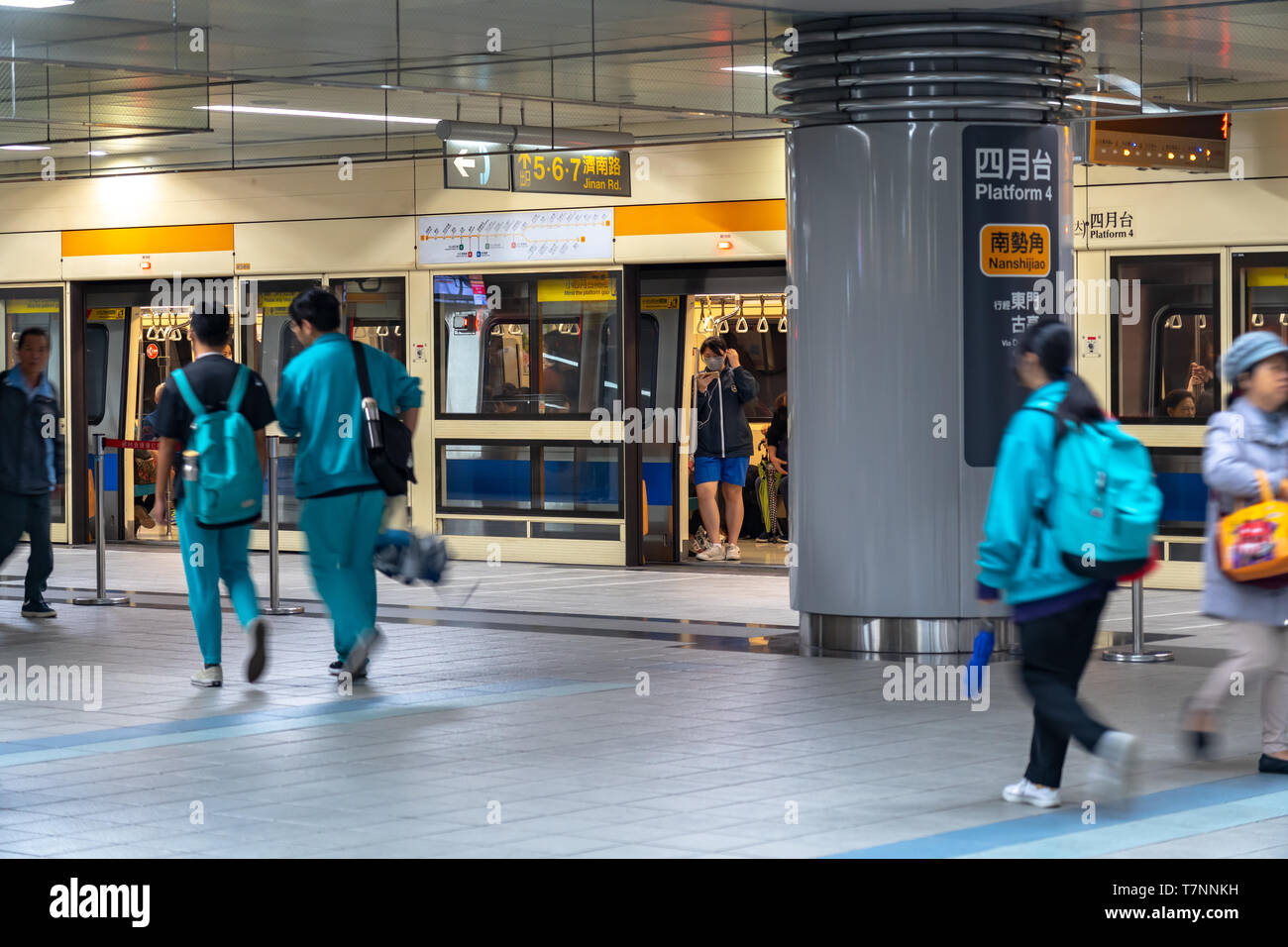 Taipei metro station hall and platform. Subway passengers walk through ...