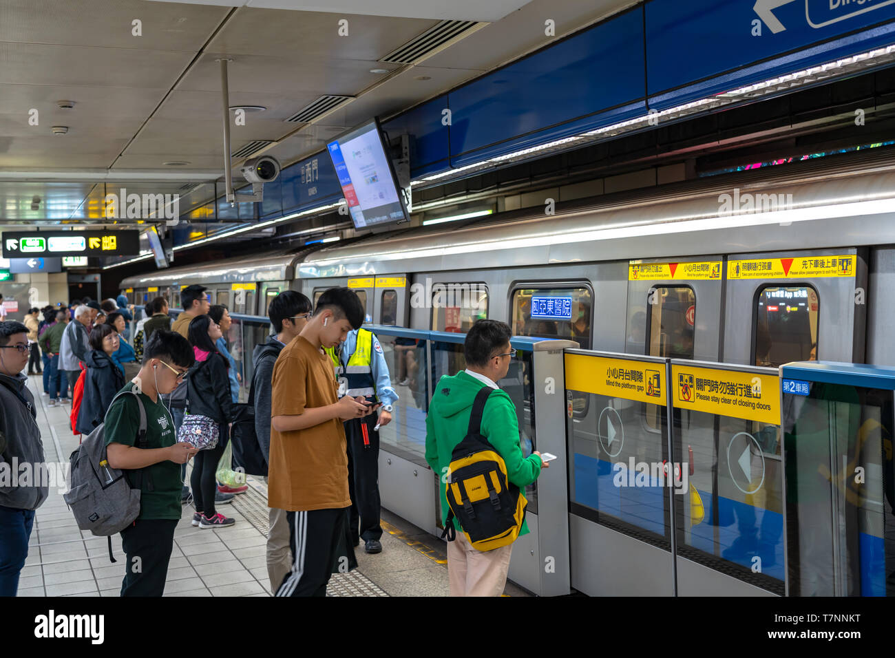 Taipei metro station hall and platform. Subway passengers walk through ...