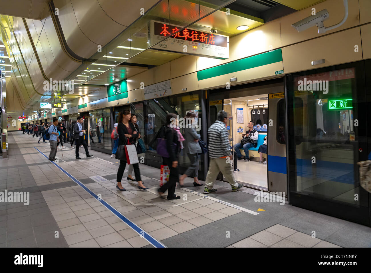 Taipei metro station hall and platform. Subway passengers walk through ...