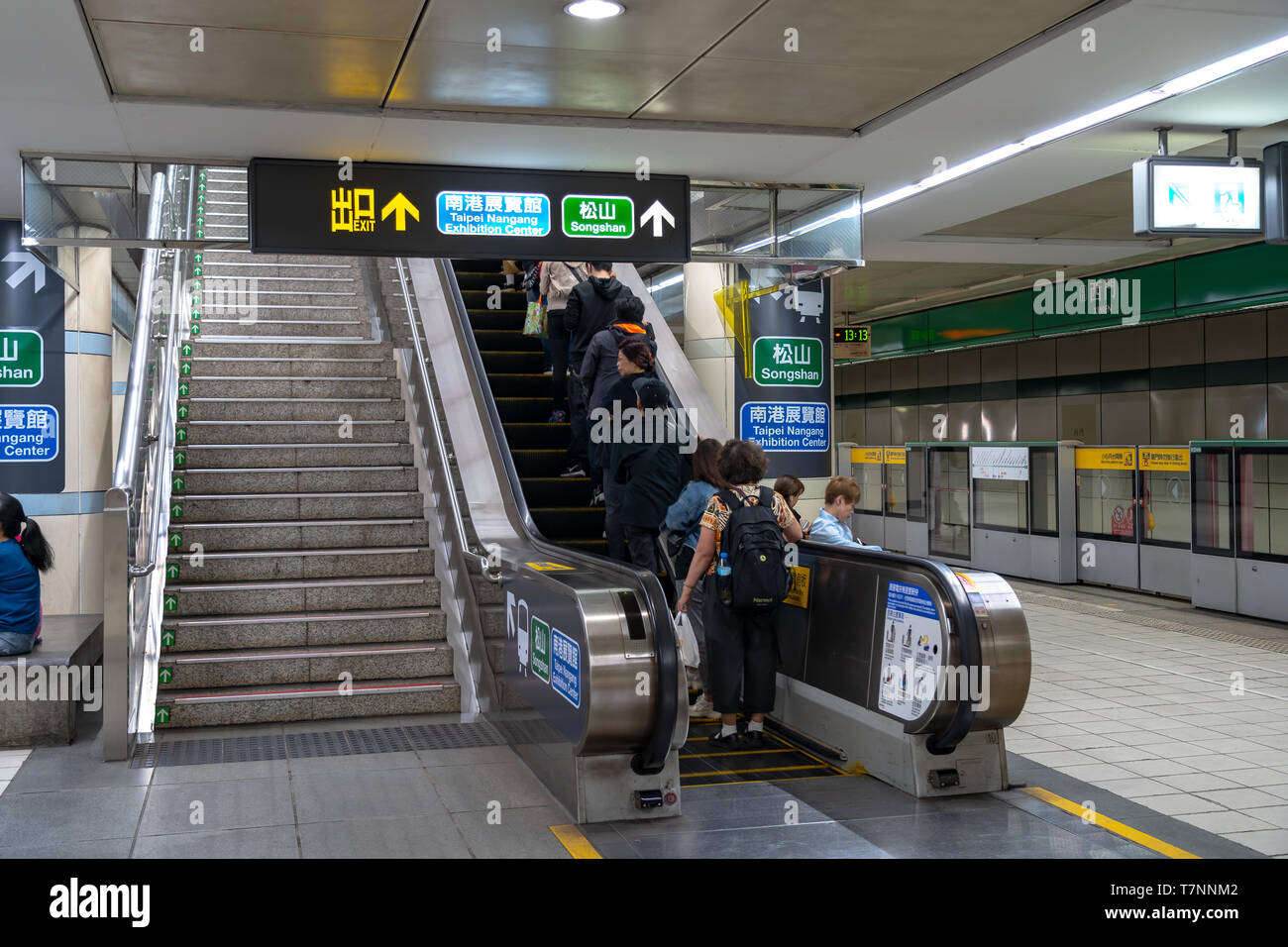 Taipei metro station hall and platform. Subway passengers walk through ...