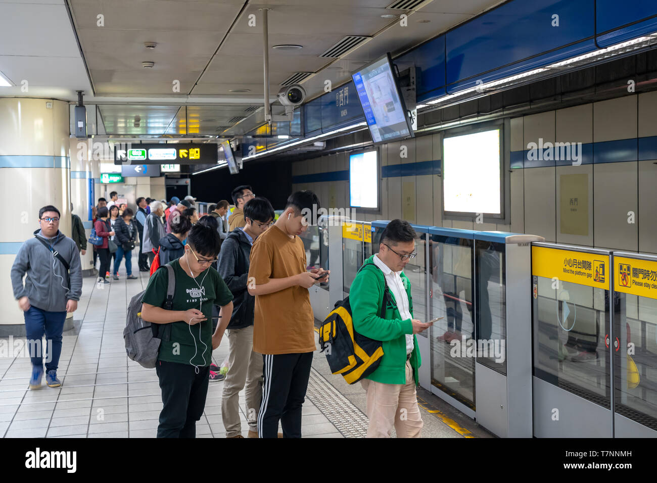 Taipei metro station hall and platform. Subway passengers walk through ...