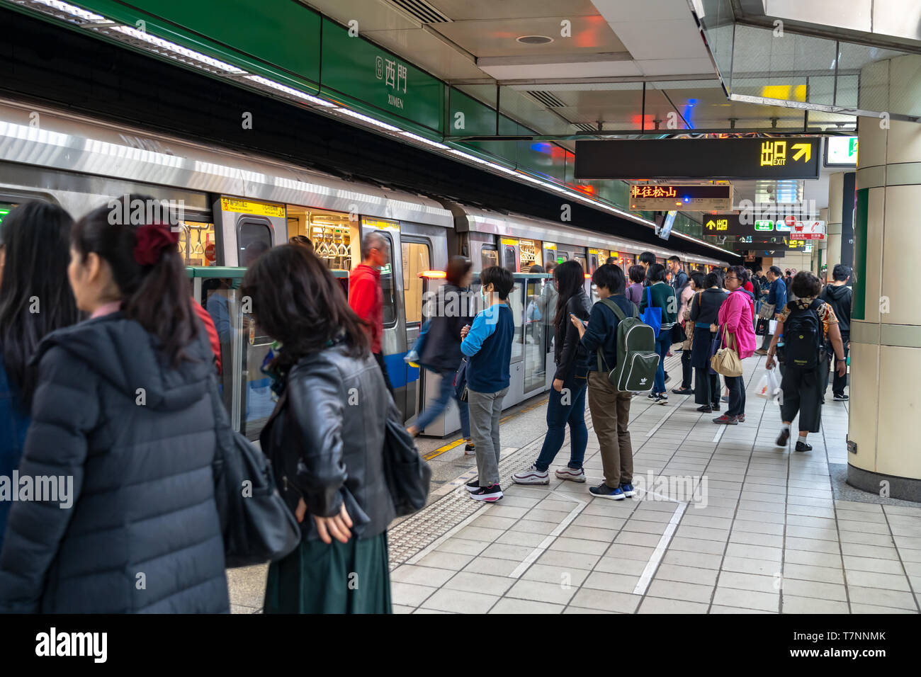 Taipei metro station hall and platform. Subway passengers walk through ...