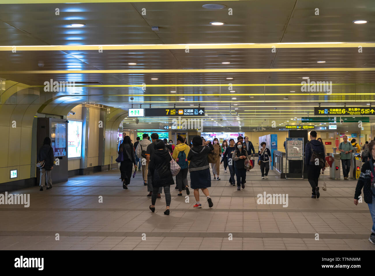 Taipei metro station hall and platform. Subway passengers walk through ...
