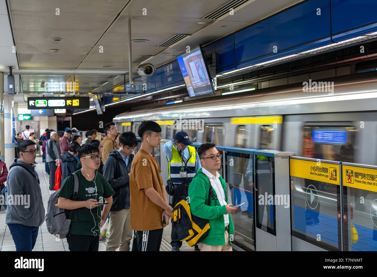 Taipei metro station hall and platform. Subway passengers walk through ...