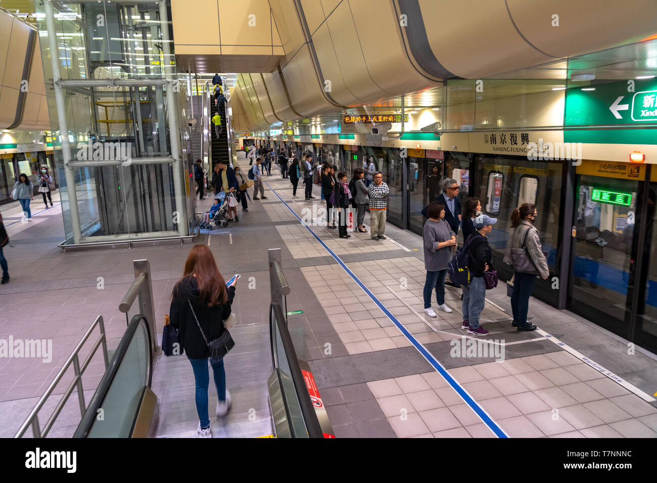 Taipei metro station hall and platform. Subway passengers walk through ...
