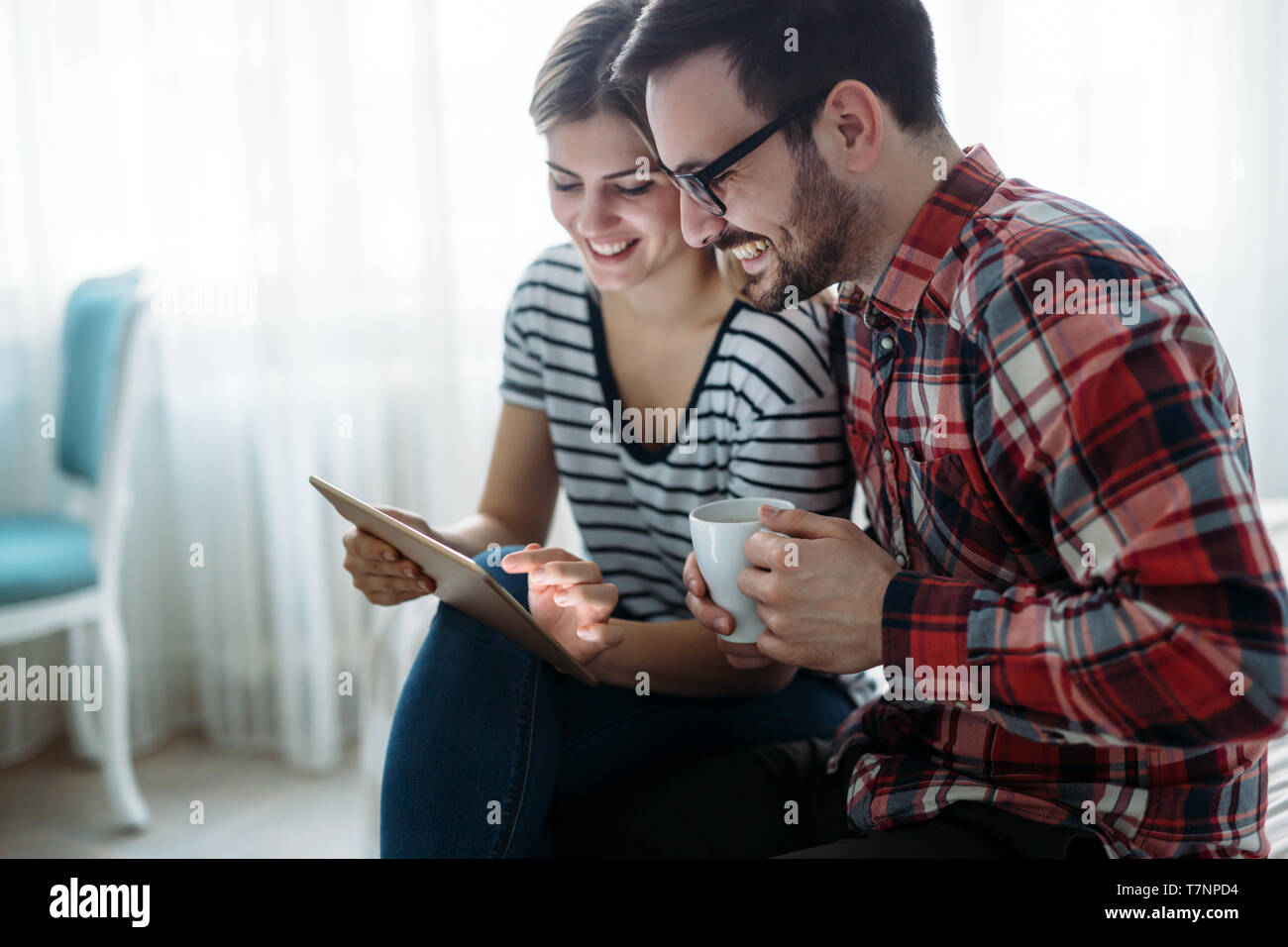 Couple smiling read tablet hi-res stock photography and images - Alamy