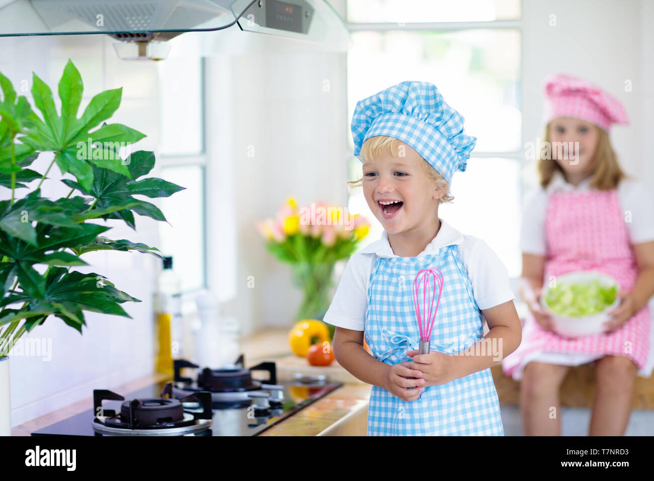 Kids cook in white kitchen. Children cooking at home. Little boy and ...