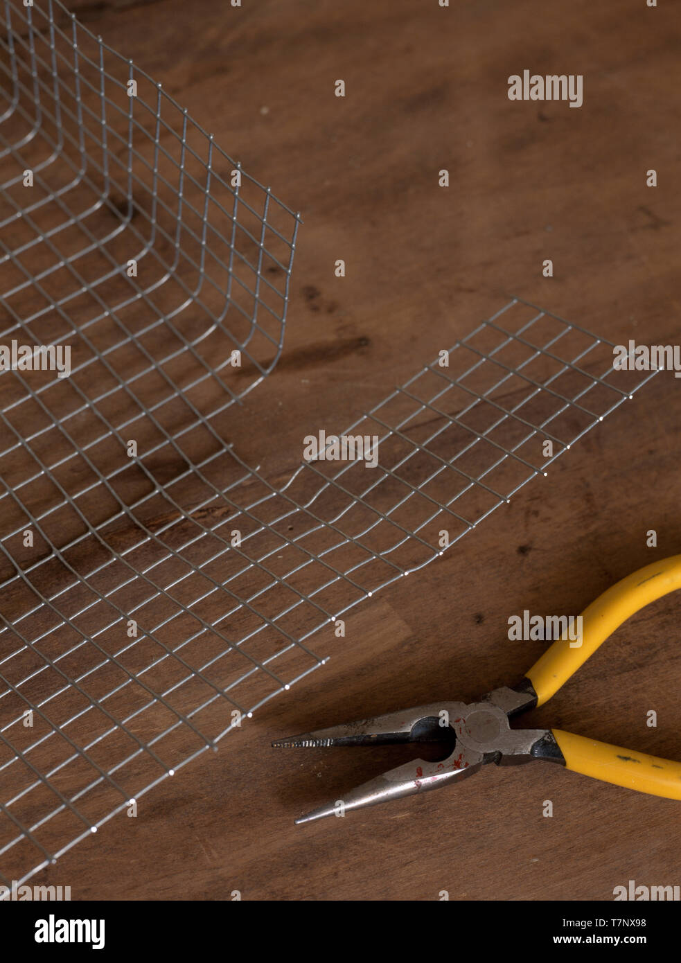 Yellow snips with wire mesh Stock Photo - Alamy