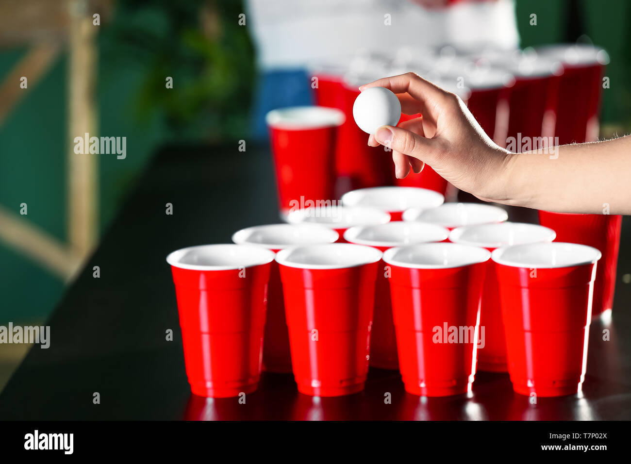 People playing beer pong game on table in bar Stock Photo - Alamy