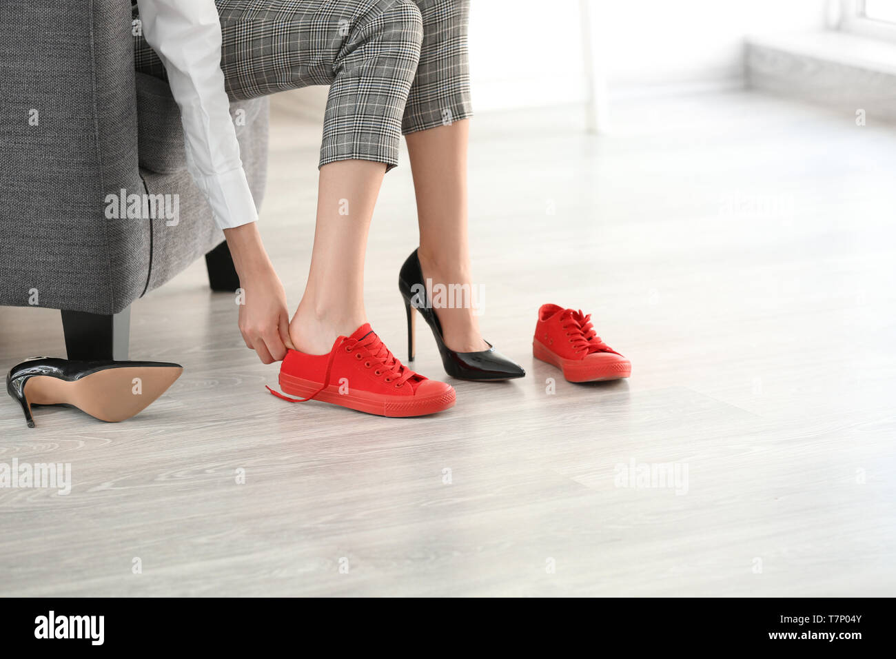 Tired woman changing shoes indoors Stock Photo - Alamy