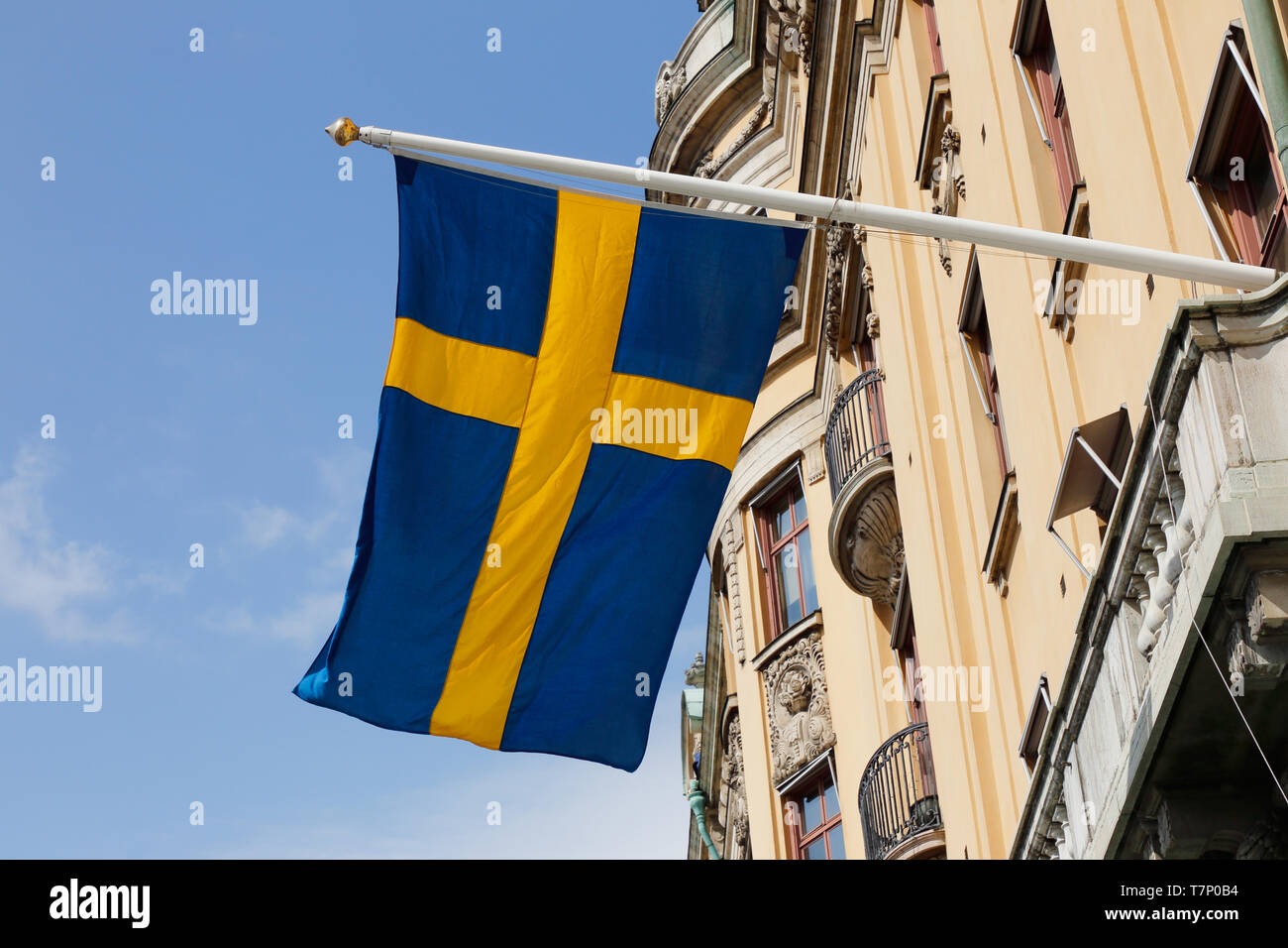 The national flag of Sweden hanging from a pole mounted on a buildings ...