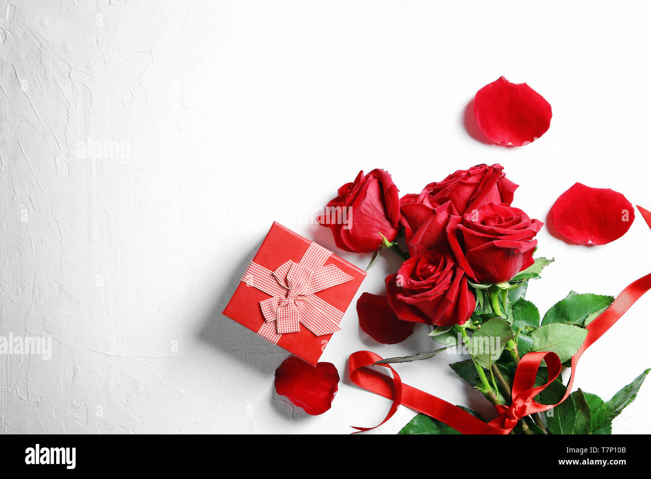 Gift box and beautiful roses on white background Stock Photo - Alamy