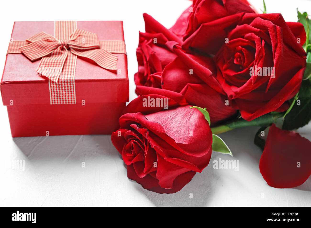 Gift box and beautiful roses on white background Stock Photo - Alamy