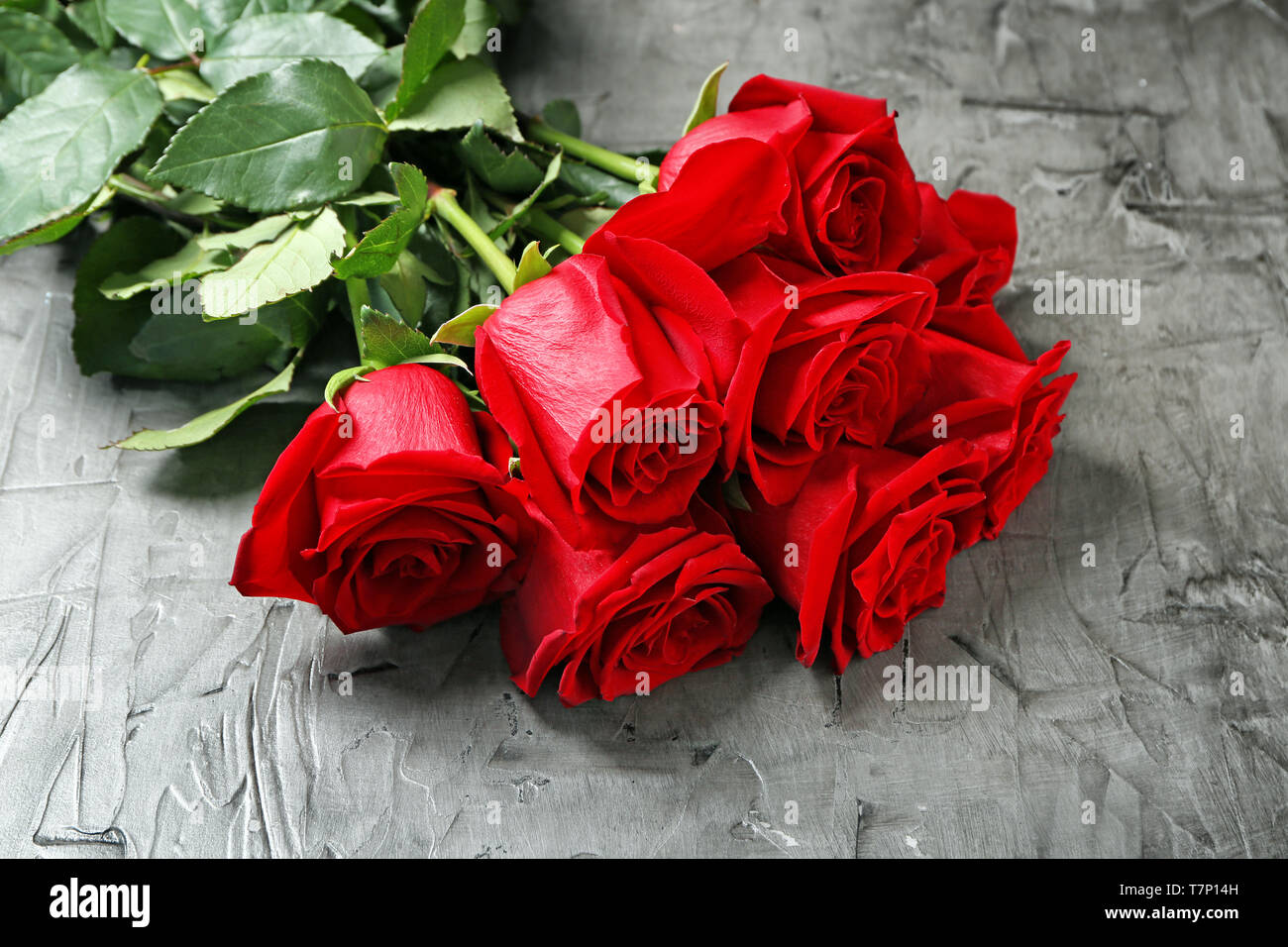 Beautiful red roses on grey textured background Stock Photo - Alamy