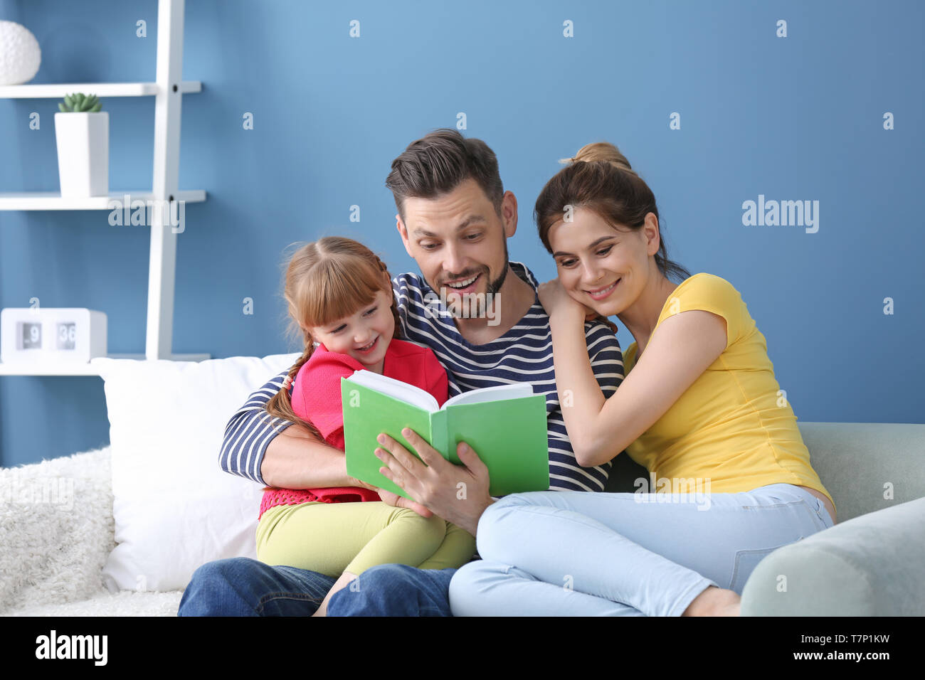 Happy family reading book together at home Stock Photo - Alamy
