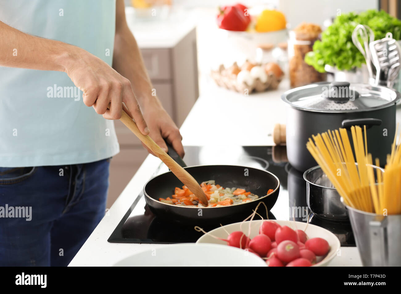 Young man cooking in kitchen Stock Photo - Alamy